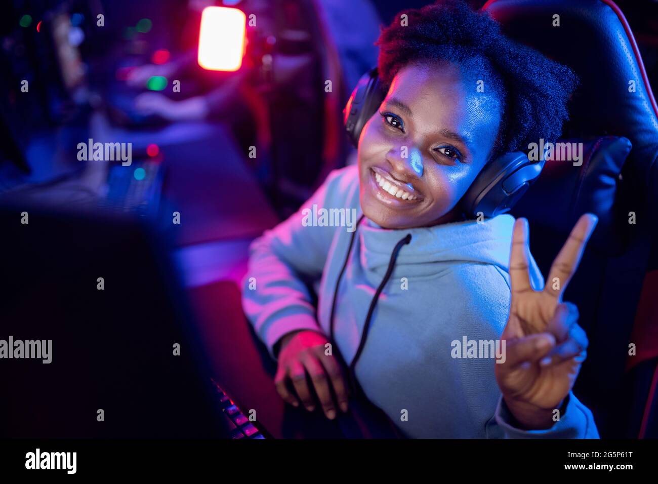 Happy Streamer gamer African American young girl smiles and play video ...