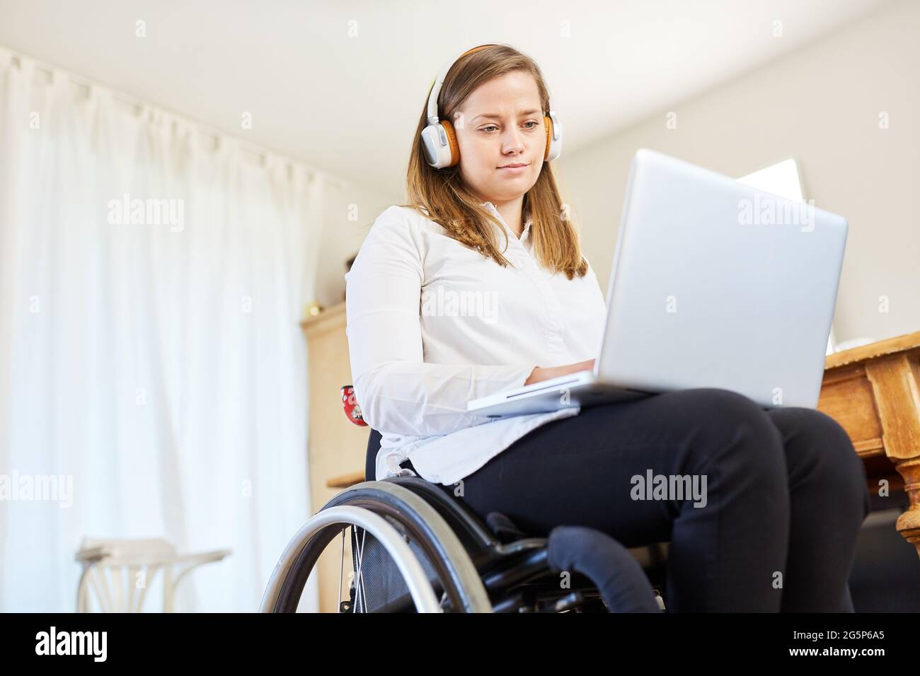 Paralyzed woman in wheelchair having a video conference online on ...