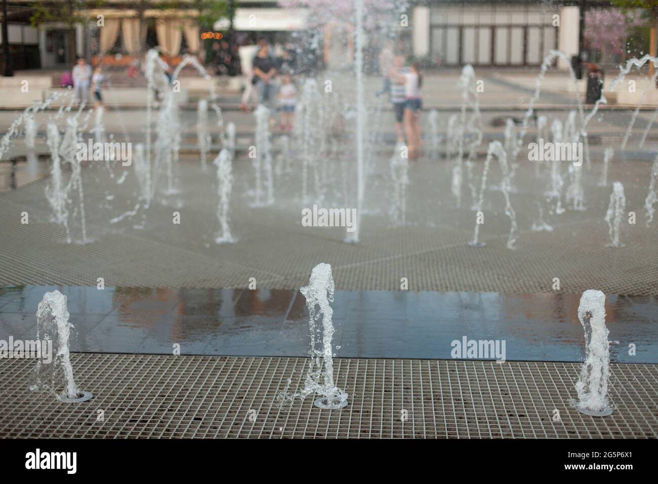 City fountain in the square. Water gushes out from sidewalks. Plane ...