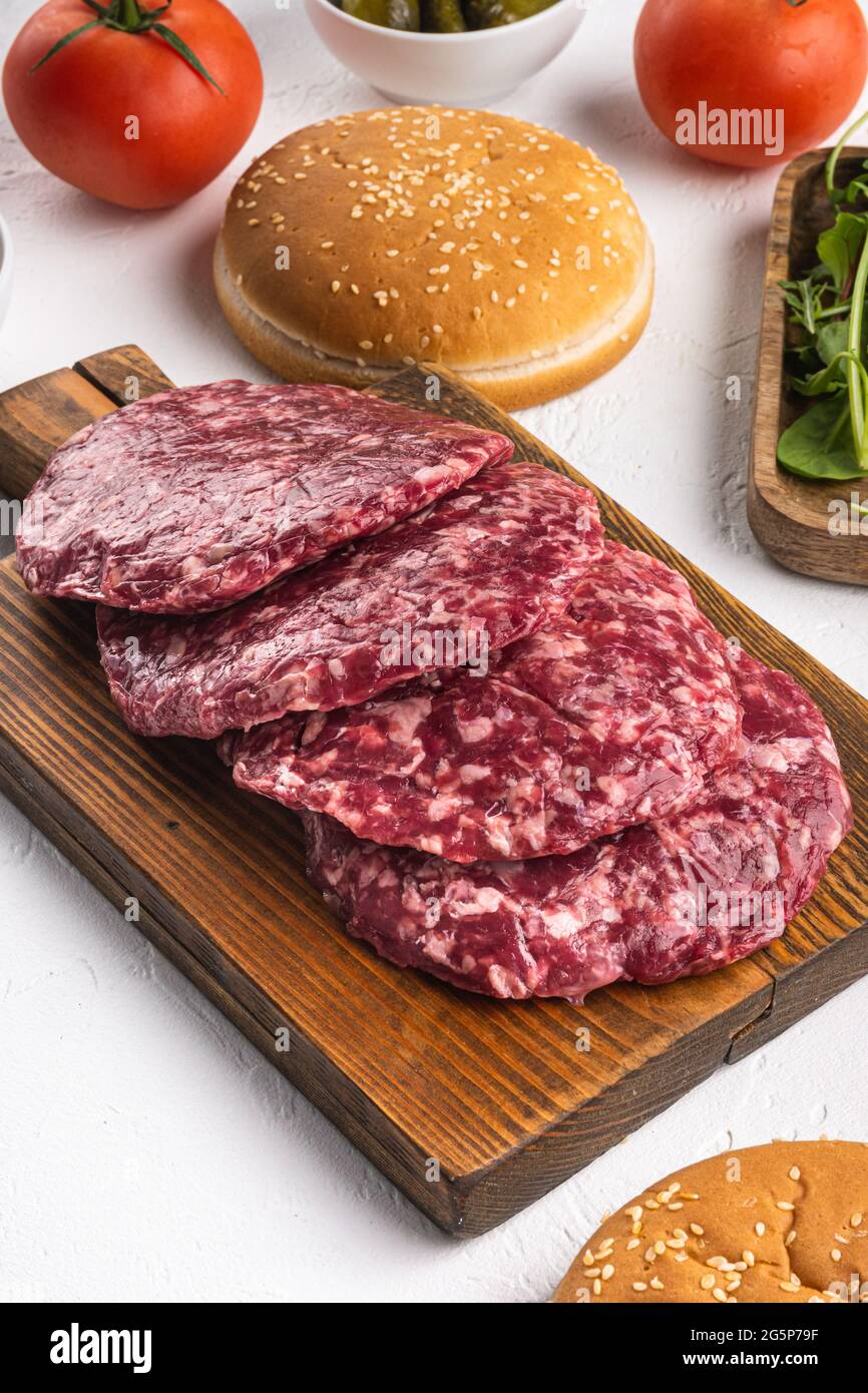 Ground Beef Patties for Grilling and Roasting set, on white stone ...