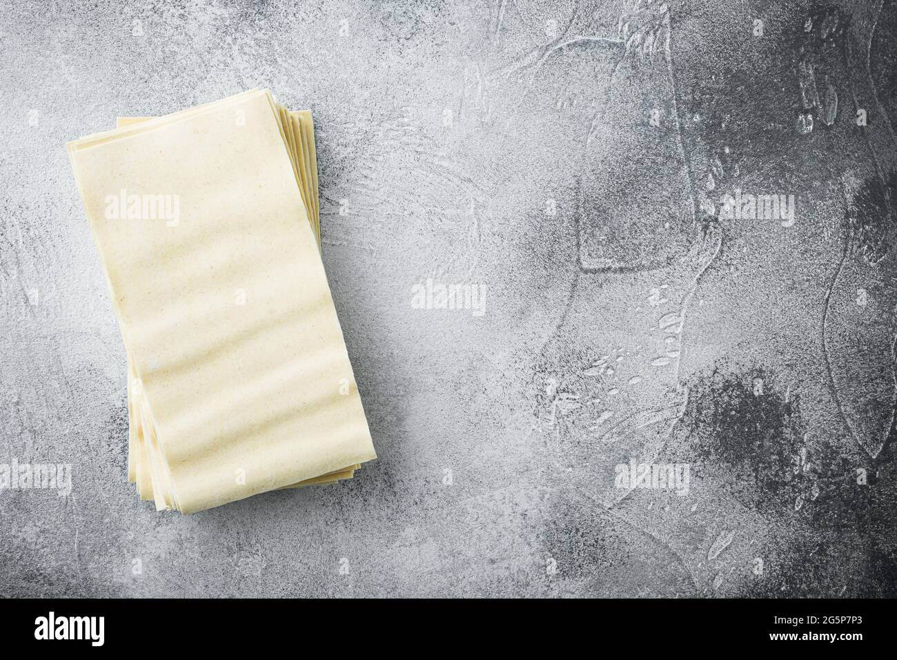 Dried uncooked lasagna pasta sheets set, on gray stone background, top ...