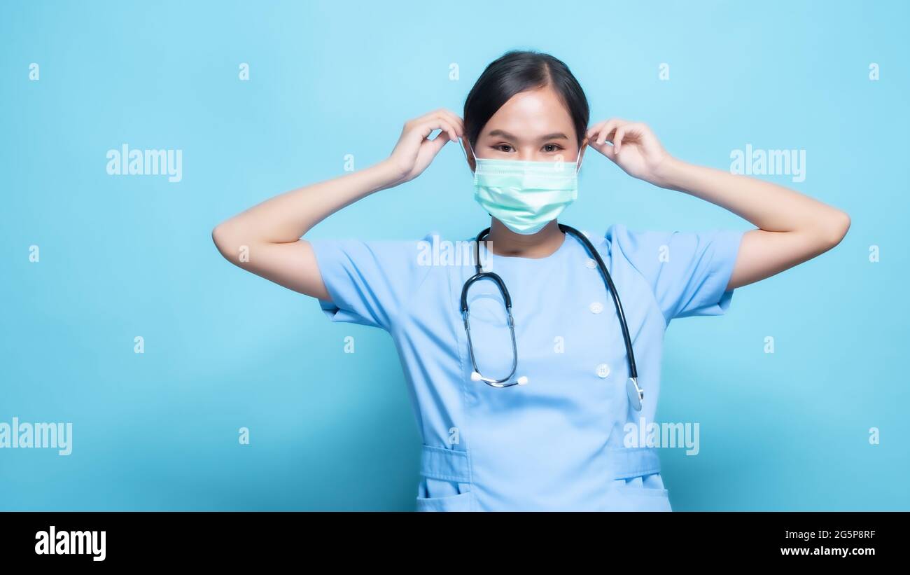 Portrait of young Asian beautiful nurse in blue uniform and wearing a ...