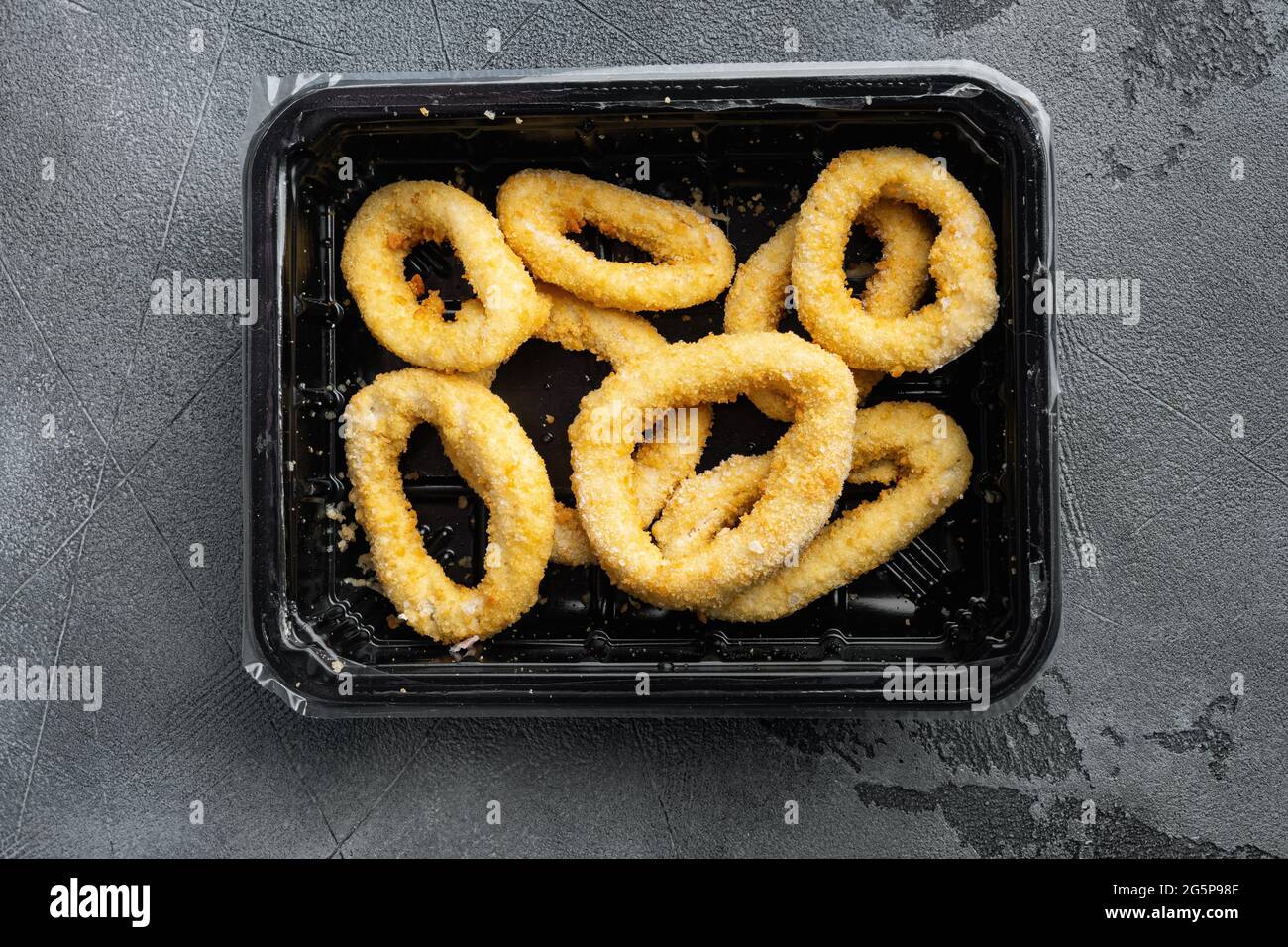 Raw crispy squid rings in breadcrumbs package set, on gray stone table ...