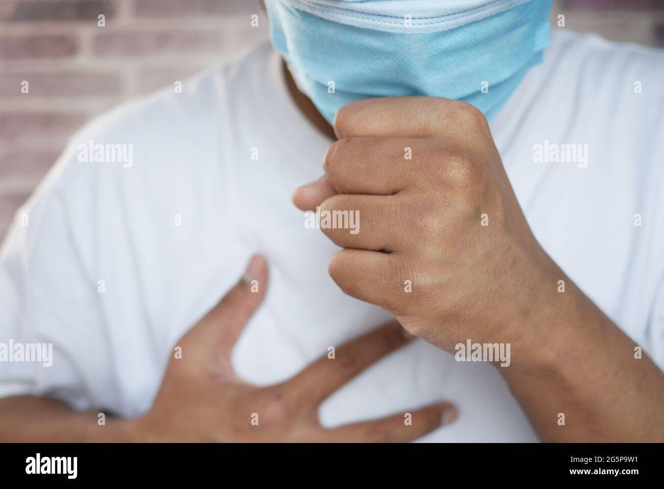 young sick man in face mask coughing and sneezes Stock Photo - Alamy