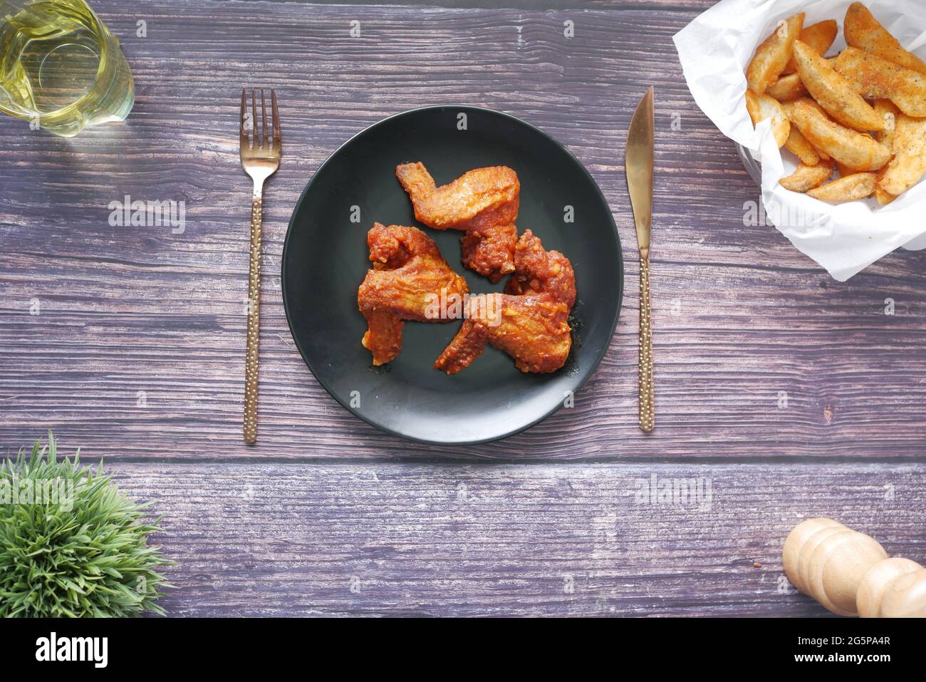 fried chicken fillets on plate and potato chips on wooden background ...