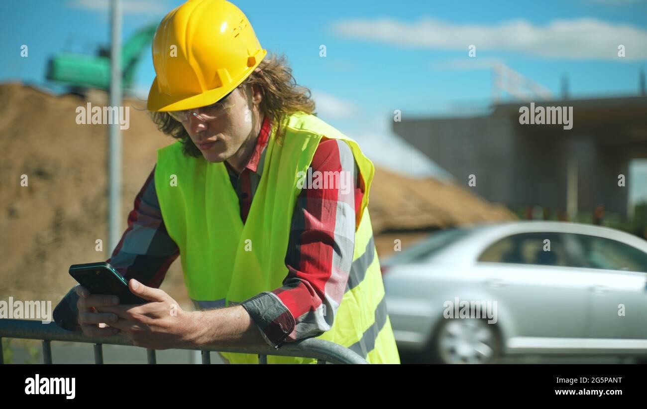 Builder talking by smartphone at construction site Stock Photo - Alamy
