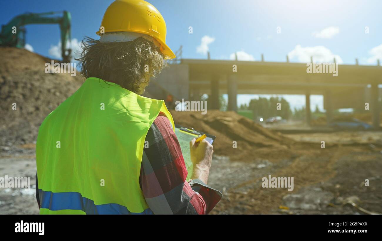Builder with documents on the background of a road junction ...