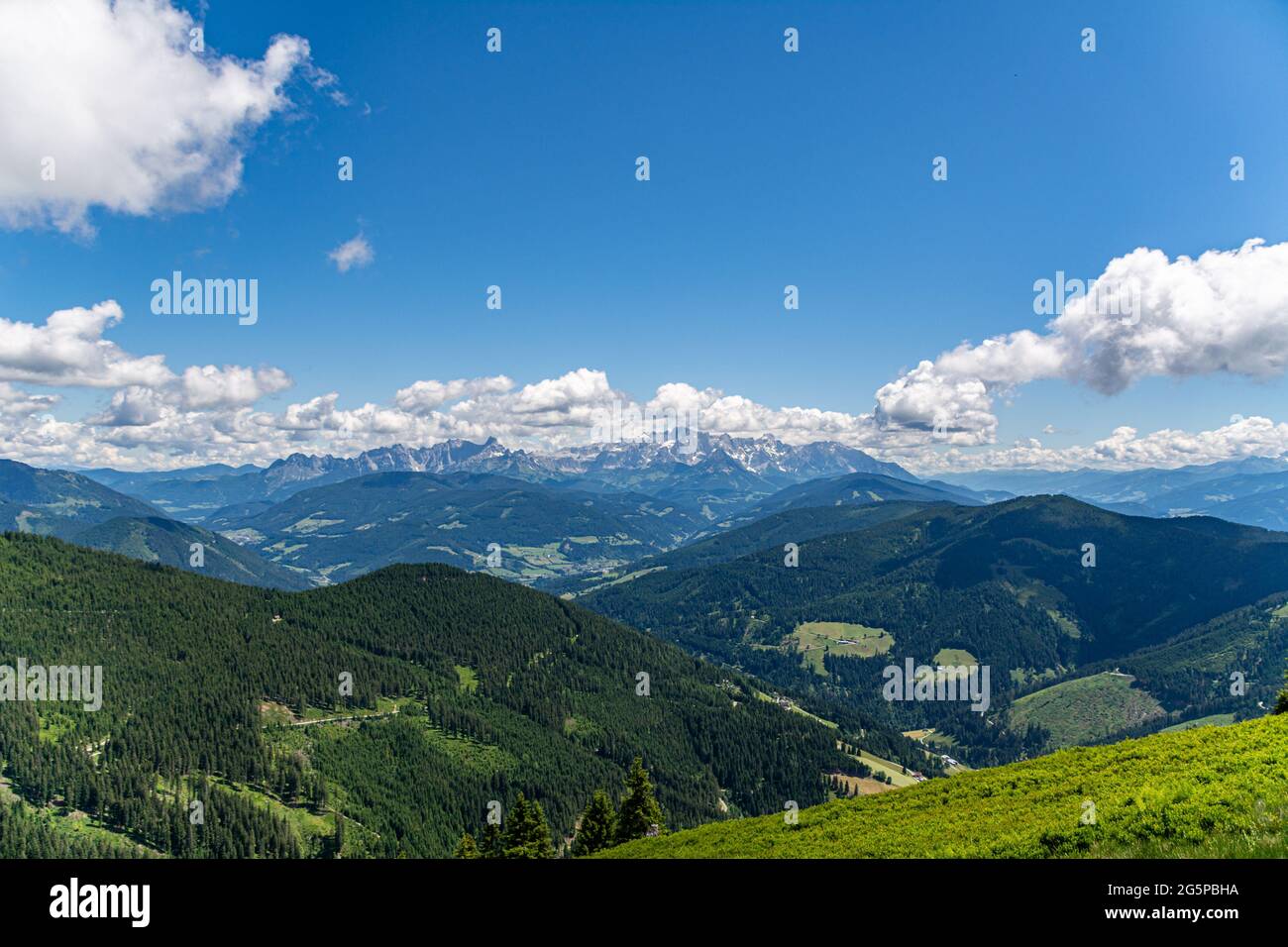 Panoramic view over the Austrian Alps with a hiking trail, trees, and a ...