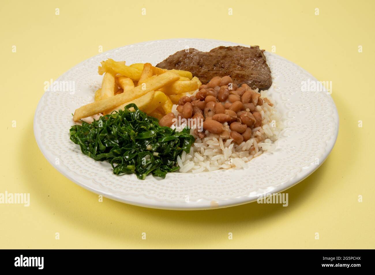typical Brazilian basic dish with rice, beans, steak, french fries and ...