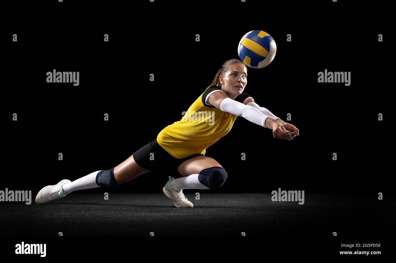 Female professional volleyball player with ball isolated on black ...