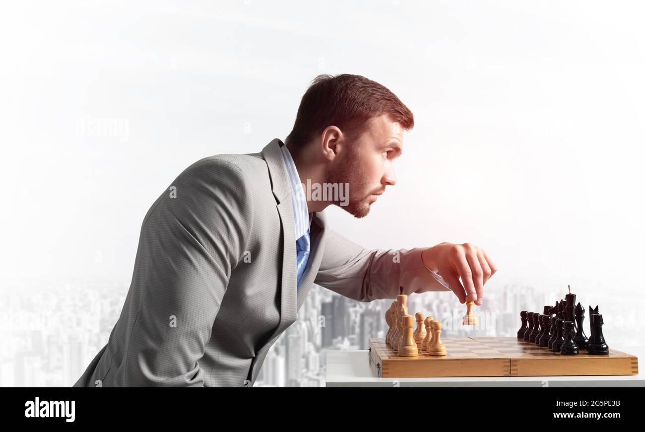 Concentrated businessman playing chess game Stock Photo - Alamy