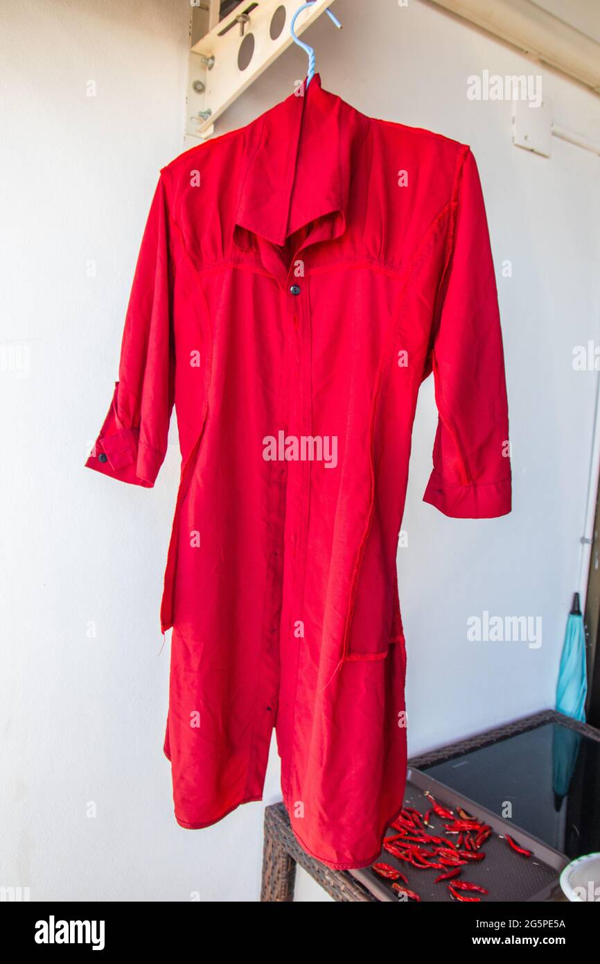 a red dress is hung up on the balcony to dry Stock Photo - Alamy