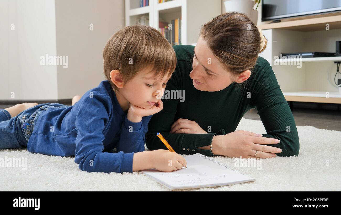 Angry mother scolding and talking to her silly son doing homework on ...