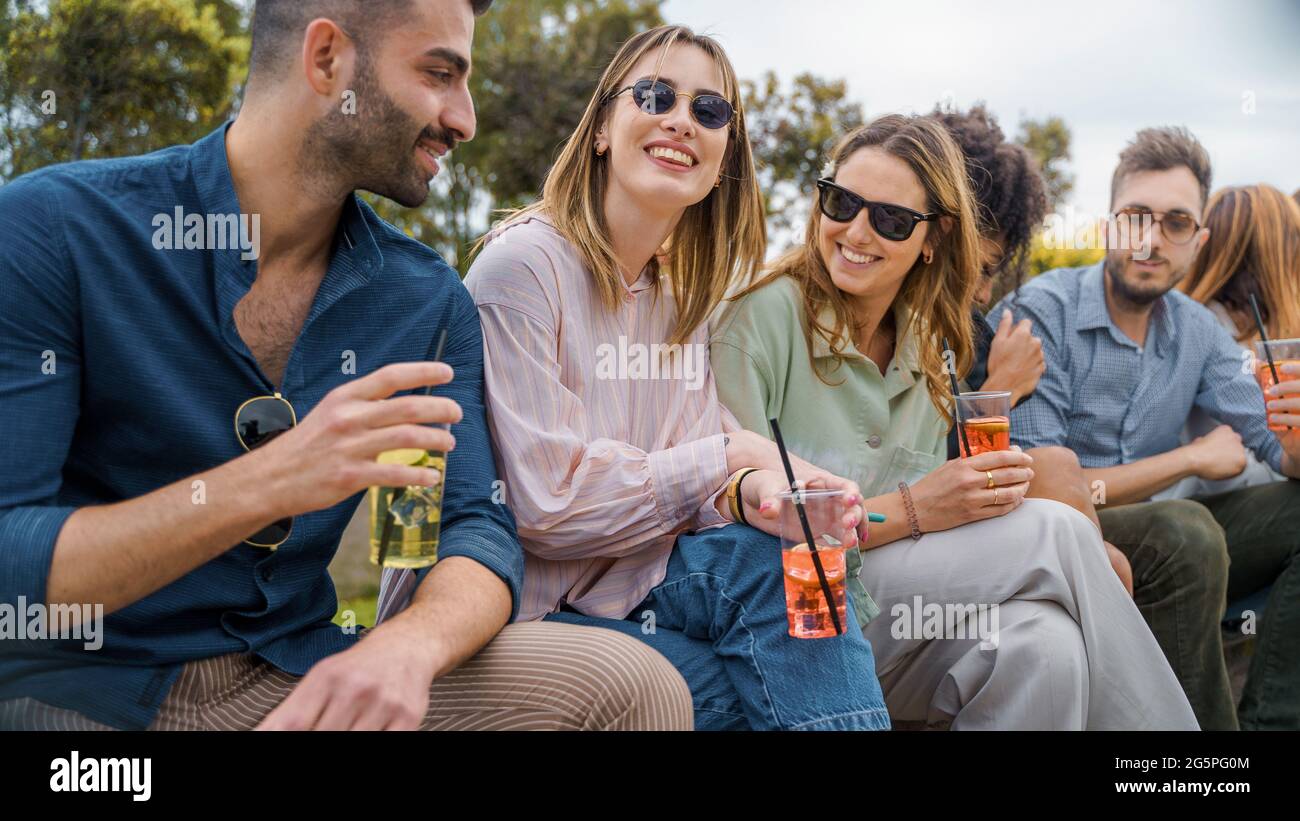 Group of happy best friends talking together sitting in a bench ...