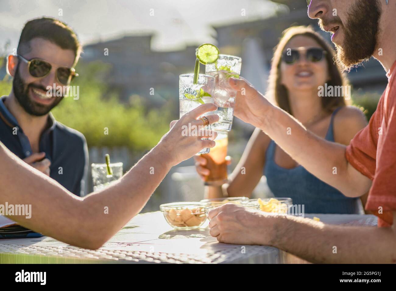 Reunion of best friend toasting with long drinks at the outdoor pub ...
