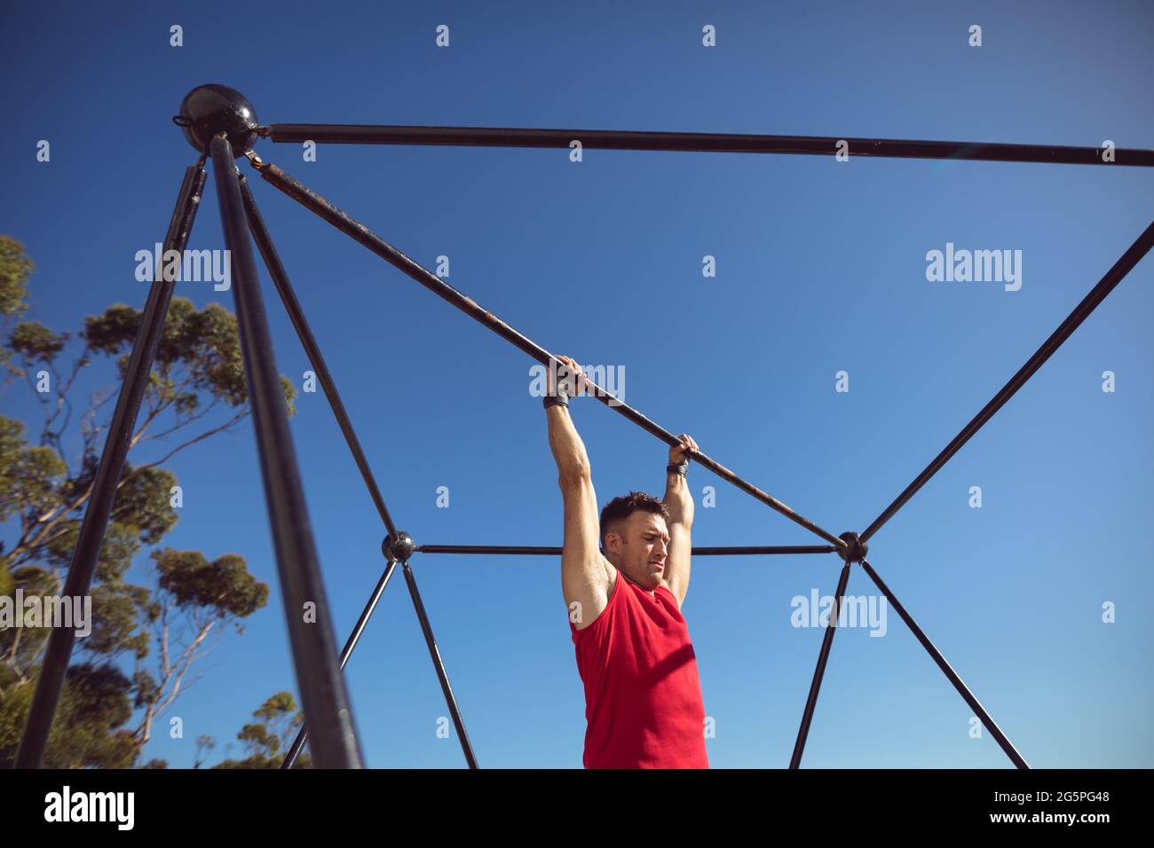 Caucasian muscular man hanging on exercise frame outdoors Stock Photo ... Caucasian muscular man hanging on exercise frame outdoors Stock Photo ...