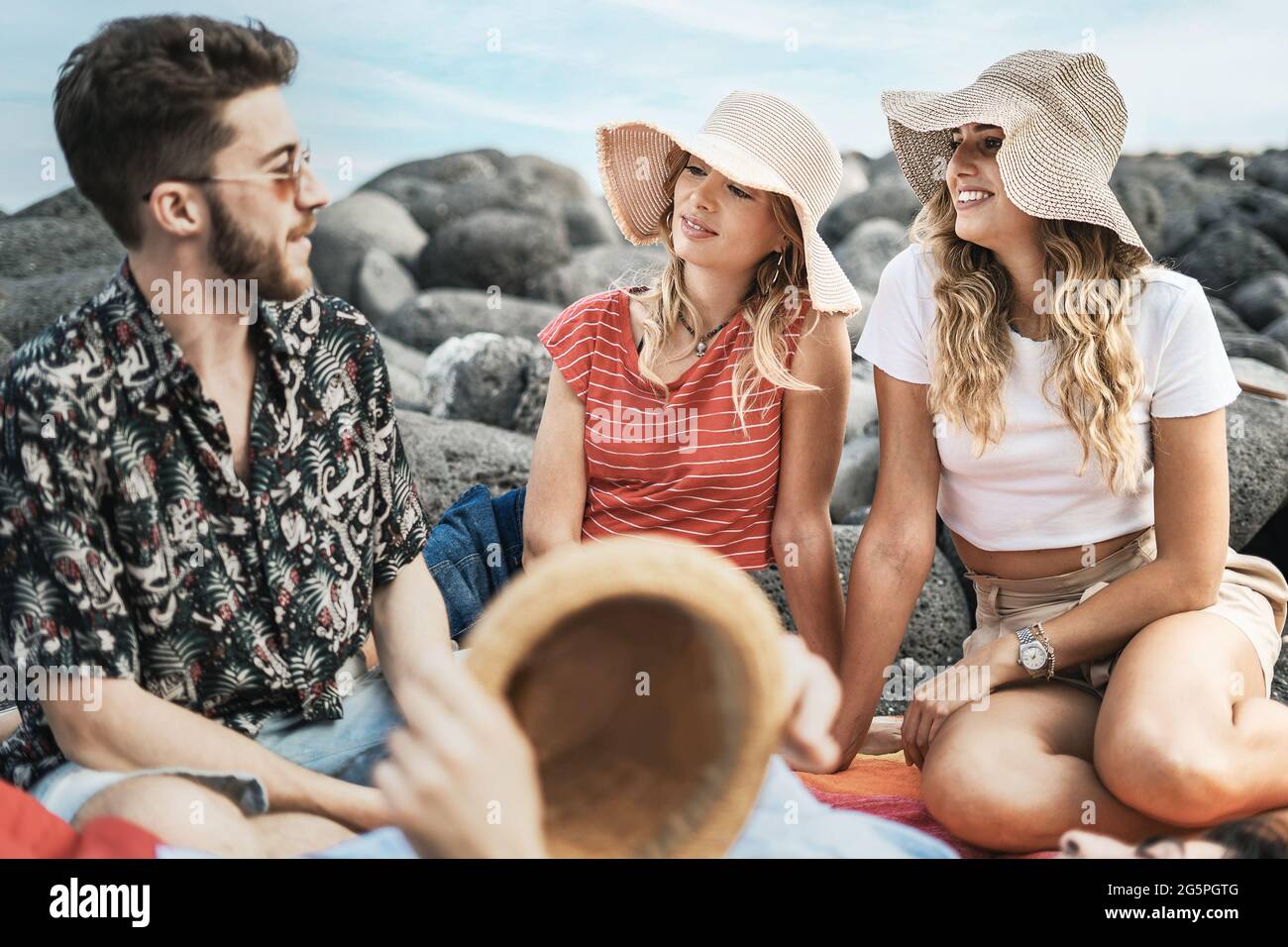 Gathering of best friends hangout outdoors at the seaside talking and ...