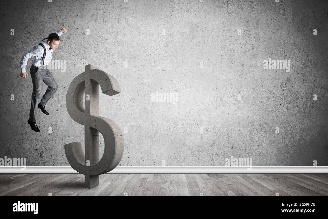 Determined banker man in empty concrete room breaking dollar figure ...