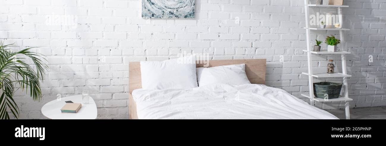 bed with white bedding in modern bedroom, banner Stock Photo - Alamy