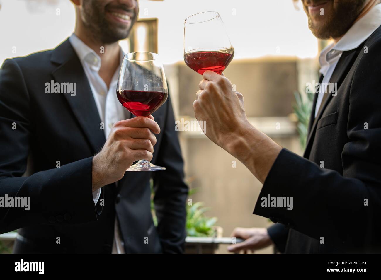 Two businessmen in suit standing in hotel room and talking together ...