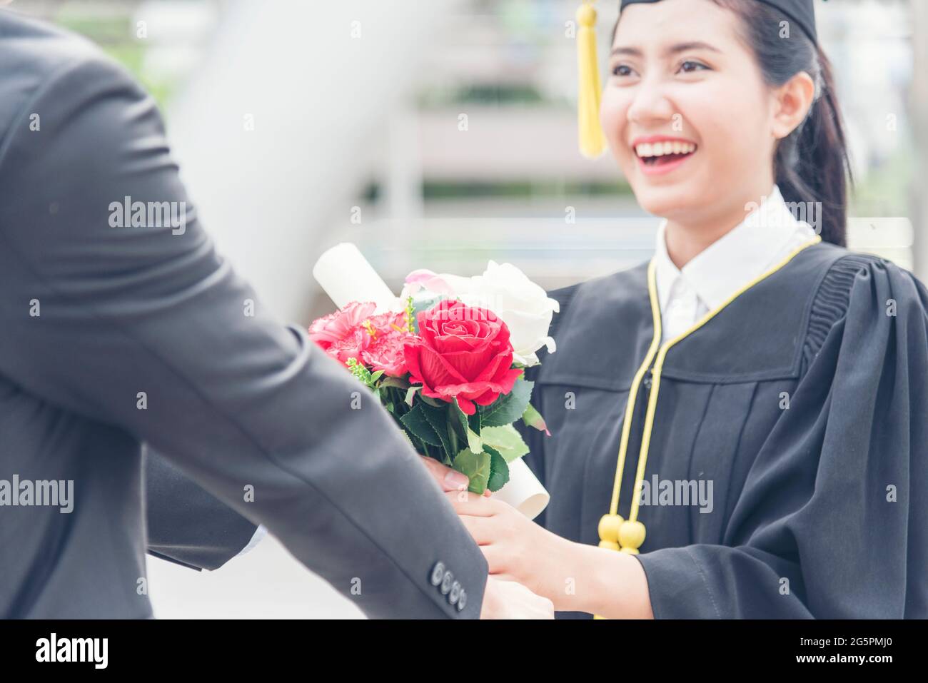 Graduated woman concept. Young smiling woman got flower after finish ...