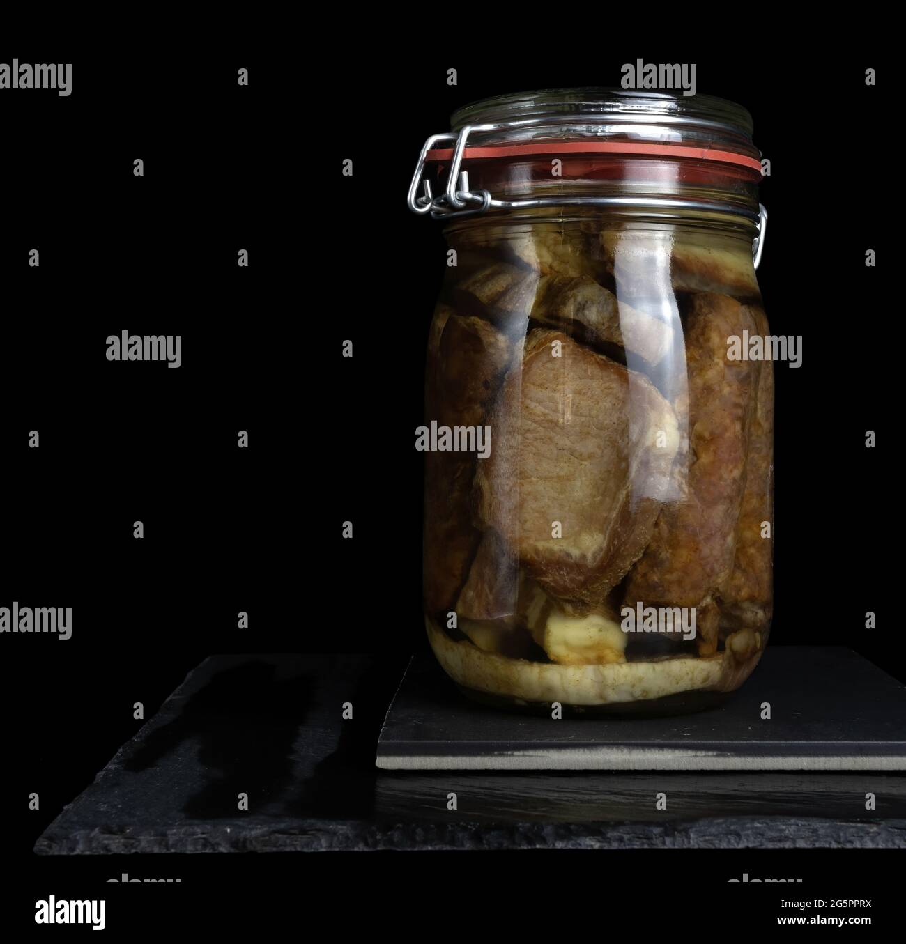 Preserved pork ribs, loin and pork sausage in a jar, black background ...