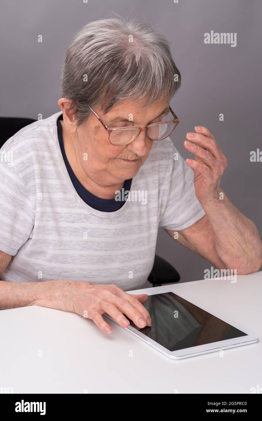 Elderly woman using a tablet Stock Photo - Alamy