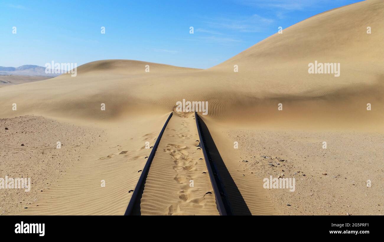 NAMIBIA. RAILWAY TRACK LOST IN THE DUNES OF THE NAMIB DESERT NEAR THE ...