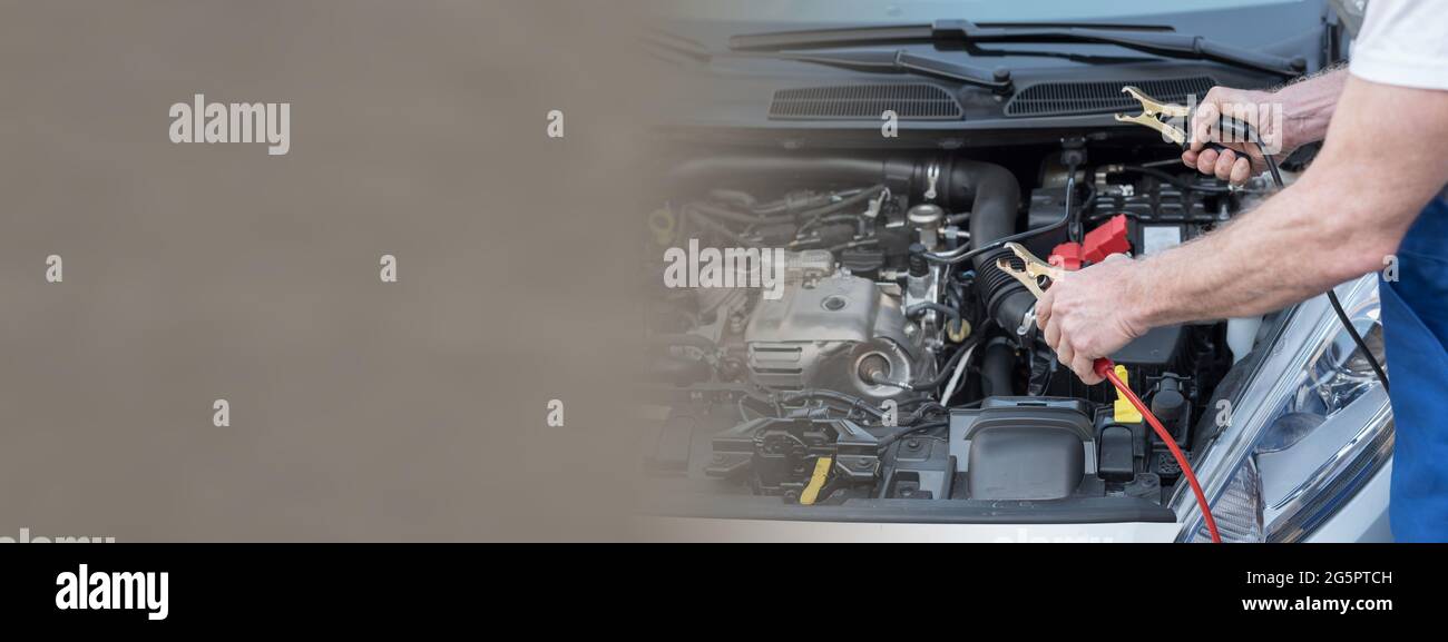 Car mechanic using cables to start a car engine Stock Photo - Alamy