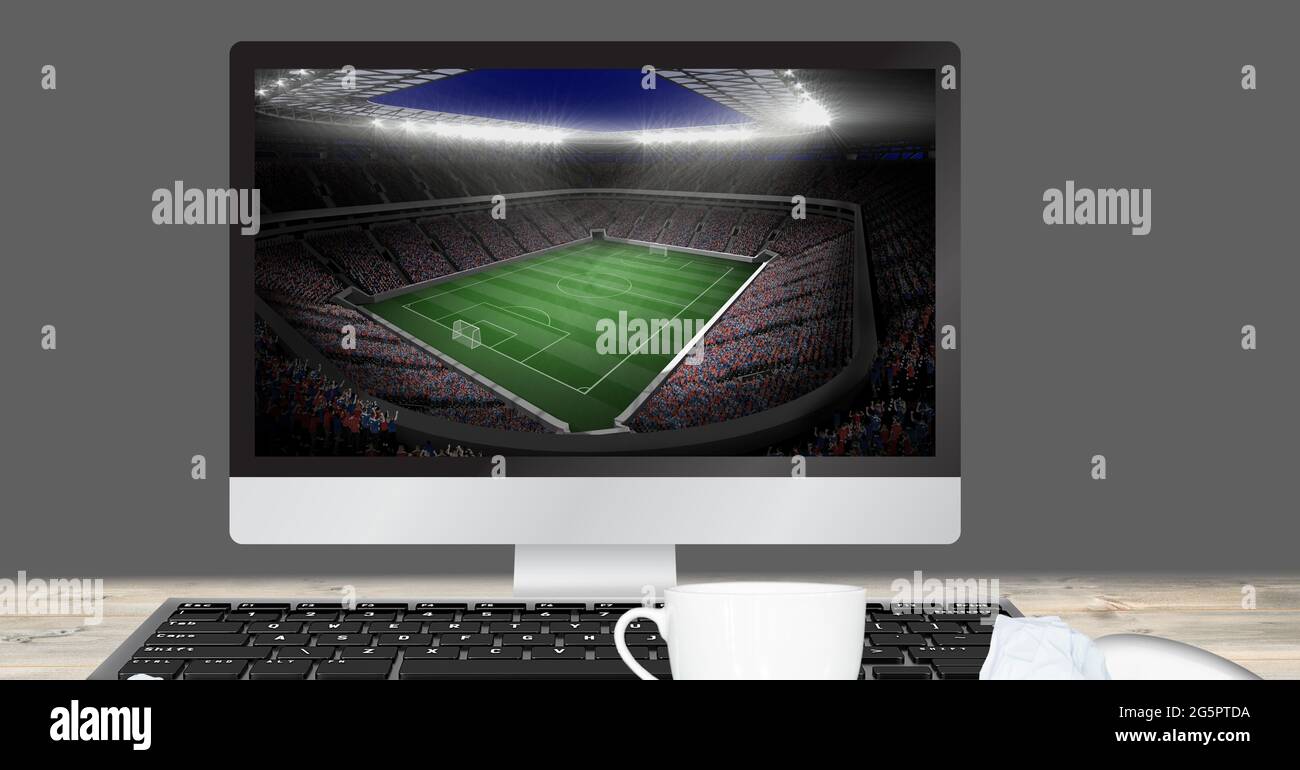 Composition of desk and cup of coffee over football stadium in computer ...