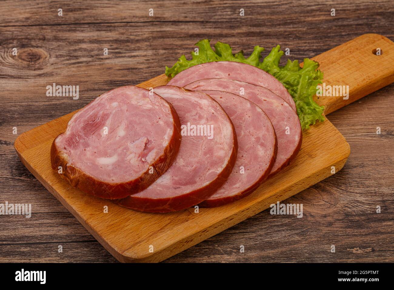 Slices of pork meat ham over wooden board Stock Photo - Alamy