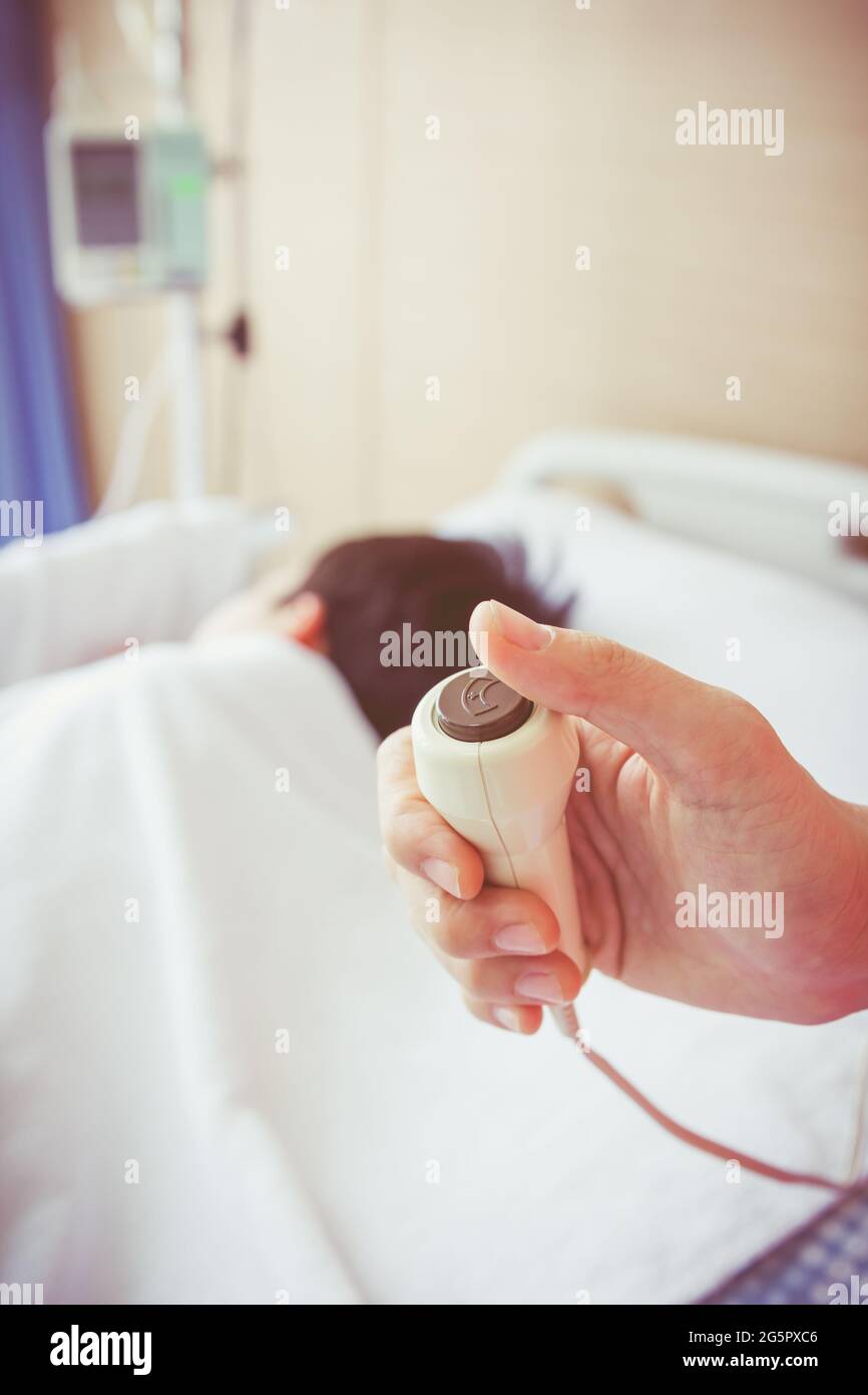 Parent hand pressing emergency nurse call button. Illness child lying ...