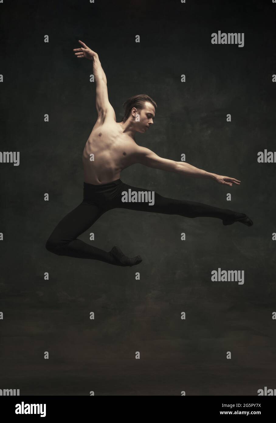 Young and graceful male ballet dancer isolated on dark background. Art ...