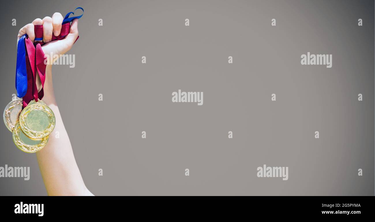 Close up of hand holding multiple medals against grey background Stock ...