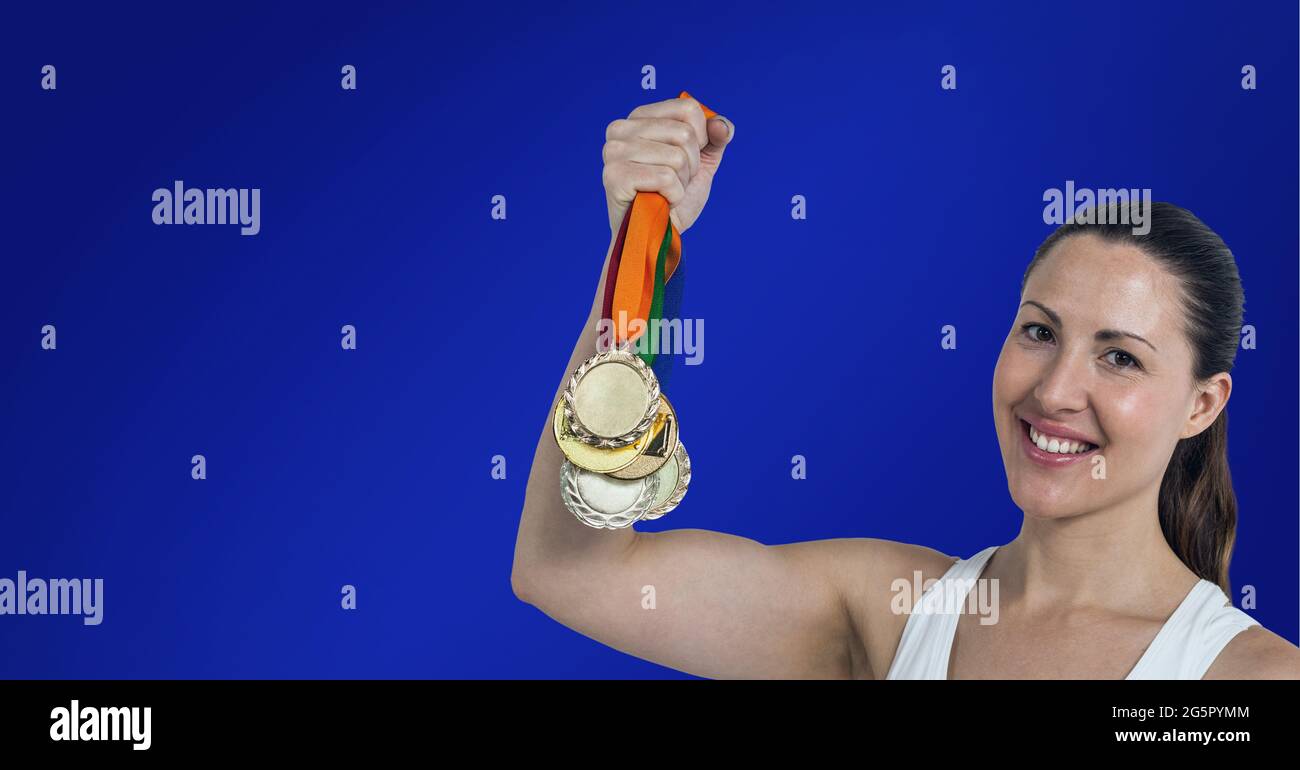 Portrait of caucasian female athlete holding multiple medals smiling ...