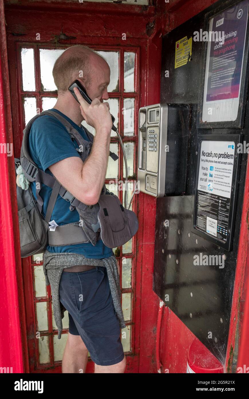 Man making a call using a handset in a british red telephone box Stock ...