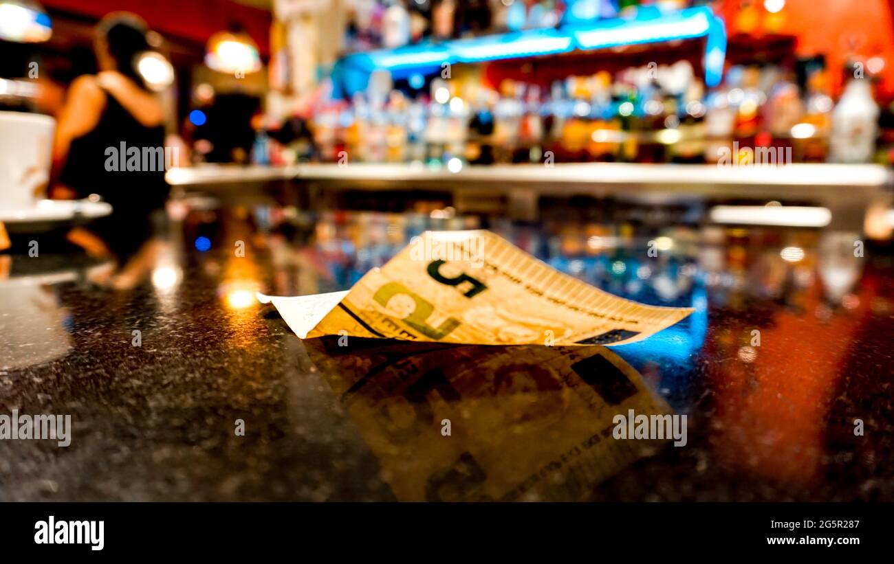 payment with a 5-euro bill at a bar counter Stock Photo - Alamy