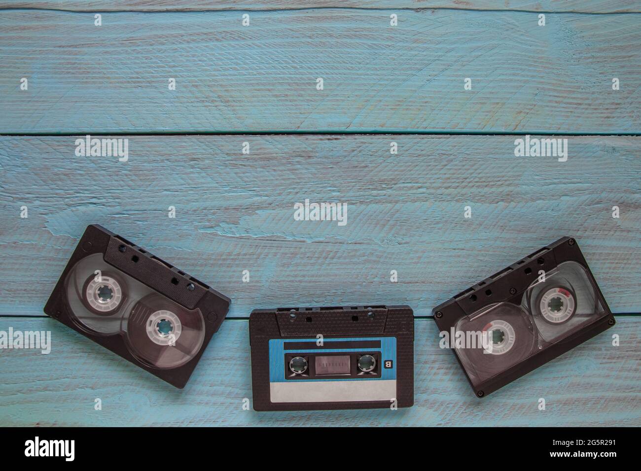 On a blue wooden background at the bottom of the frame are three audio ...