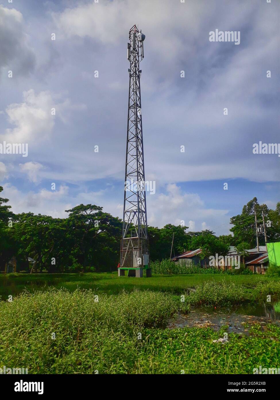 Vertical shot of GP tower in a field with houses and trees Stock Photo ...