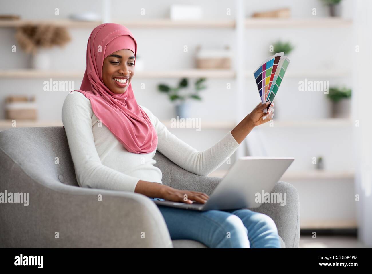 Black Islamic Female Designer Working With Laptop And Color Swatches At ...