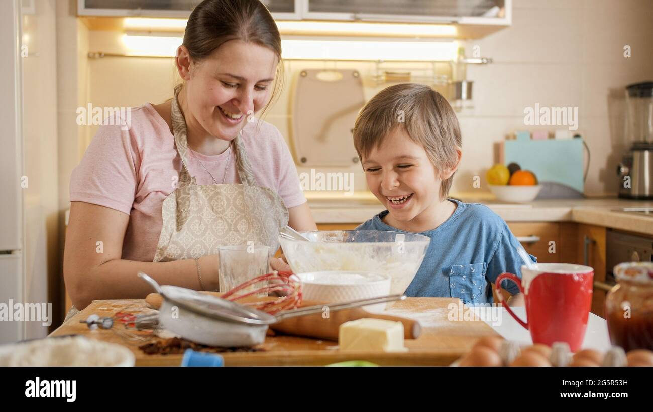 Happy laughing boy with mother playing and fooling around while making ...