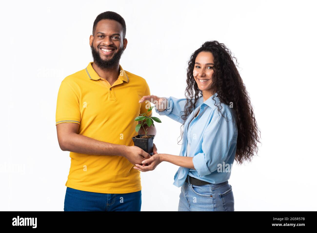 Multicultural Couple Holding Pot With Green Plant Over White Background ...