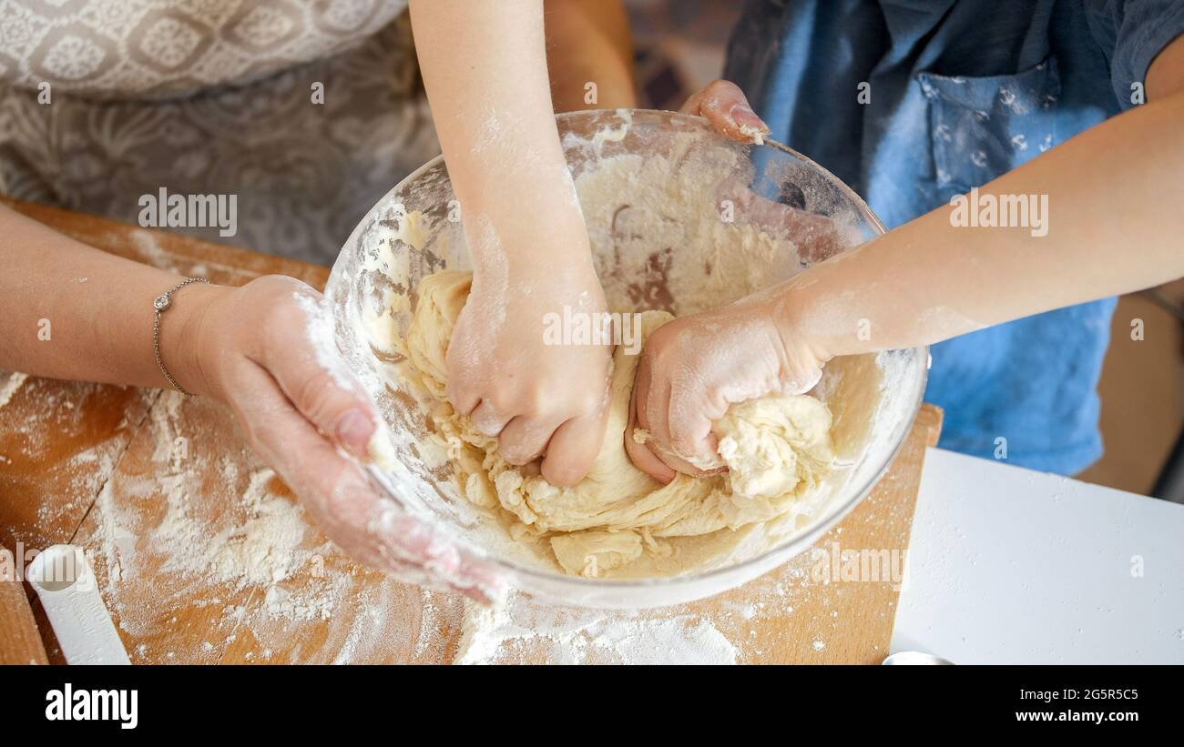 Closeup of little boy mixing dough in big glass bowl. Children cooking ...