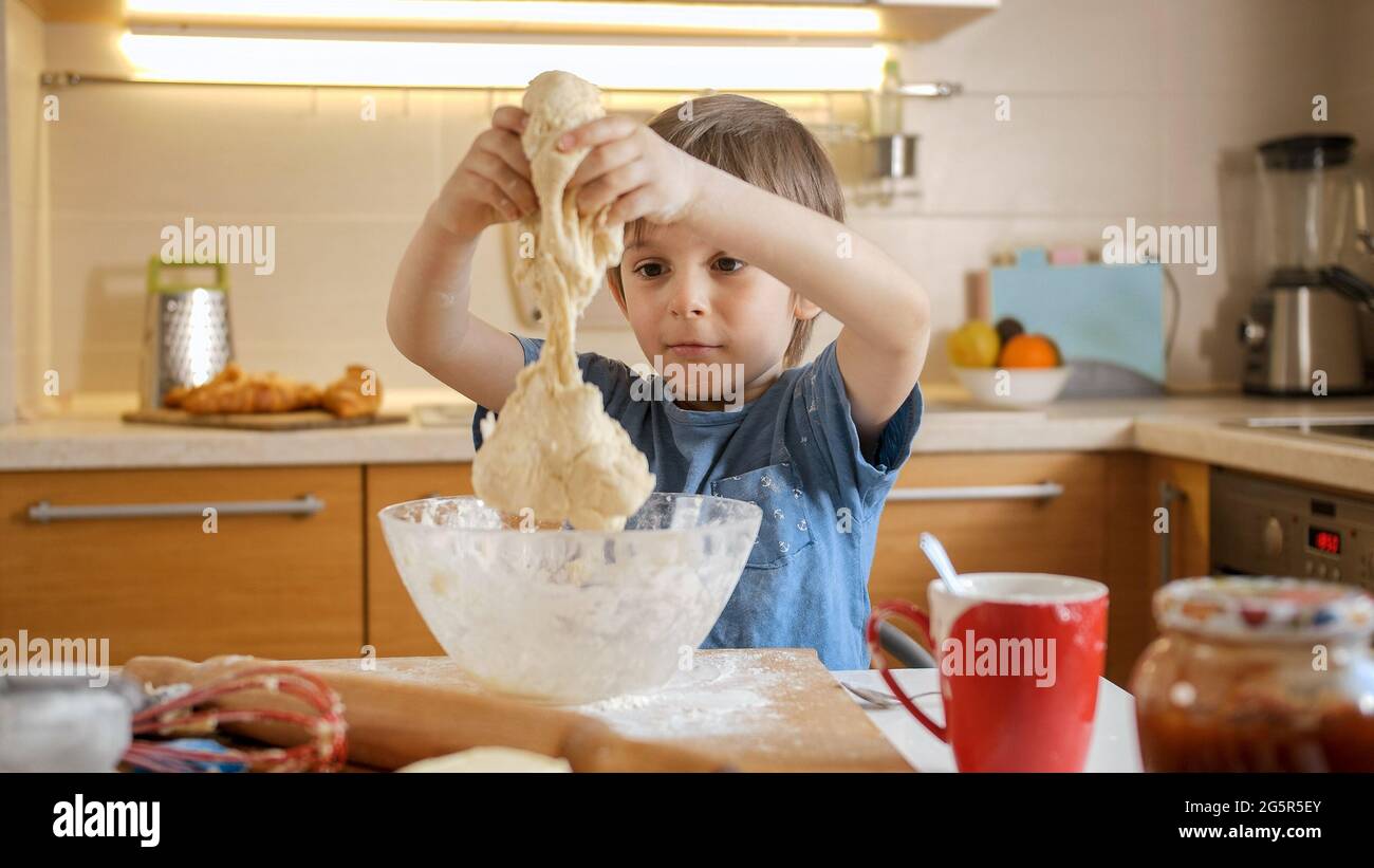 Cute little boy playing and having fun with soft dough for biscuits on ...