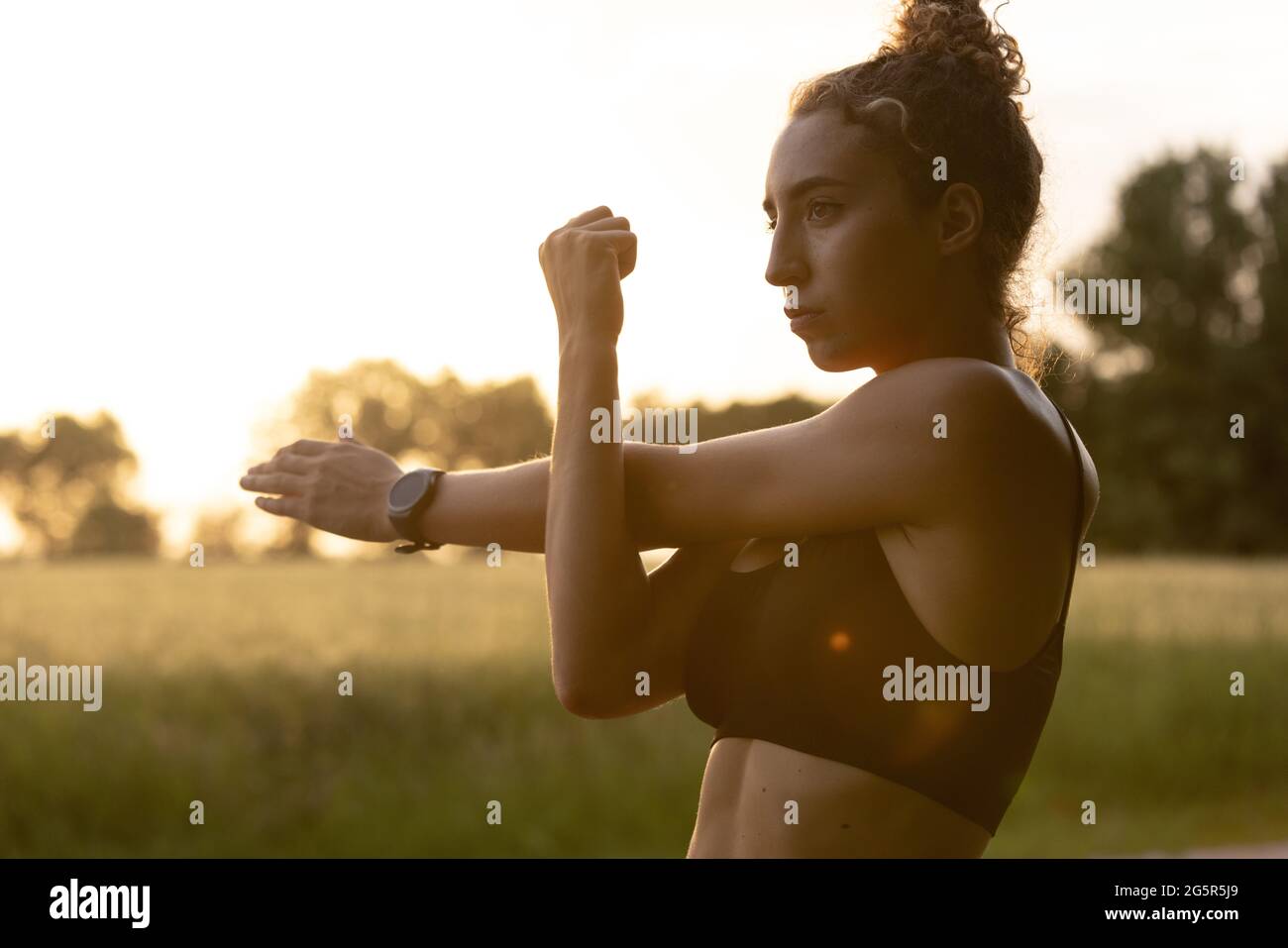 Young female runner, athlete is jogging at road in summer sunshine. Beautiful caucasian woman ...
