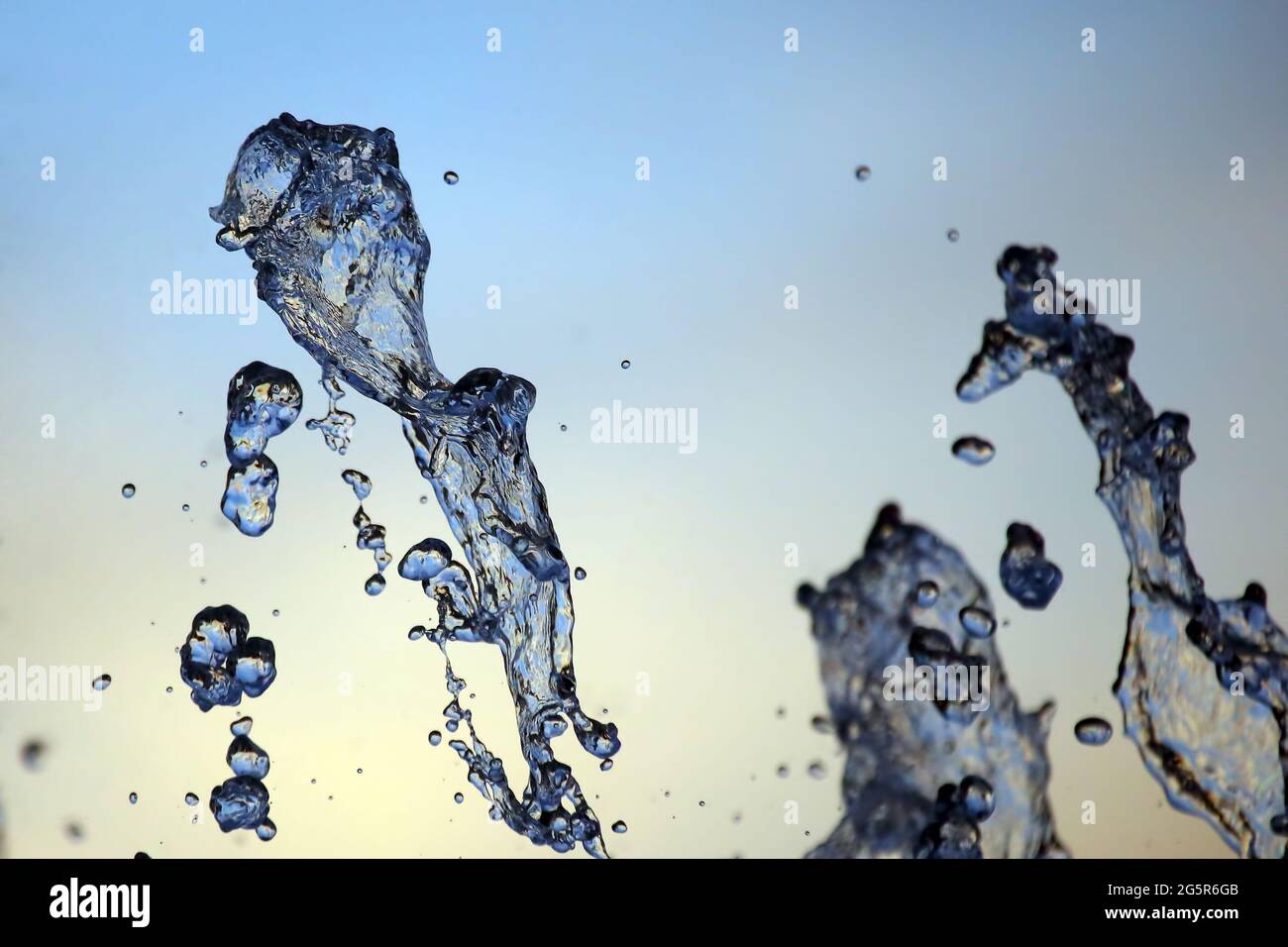 Drops of a falling water fountain against the evening sky. natural ...
