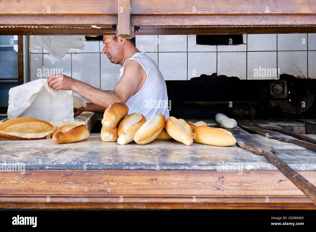 Baker cooking bread at a traditional authentic bakehouse Stock Photo ...