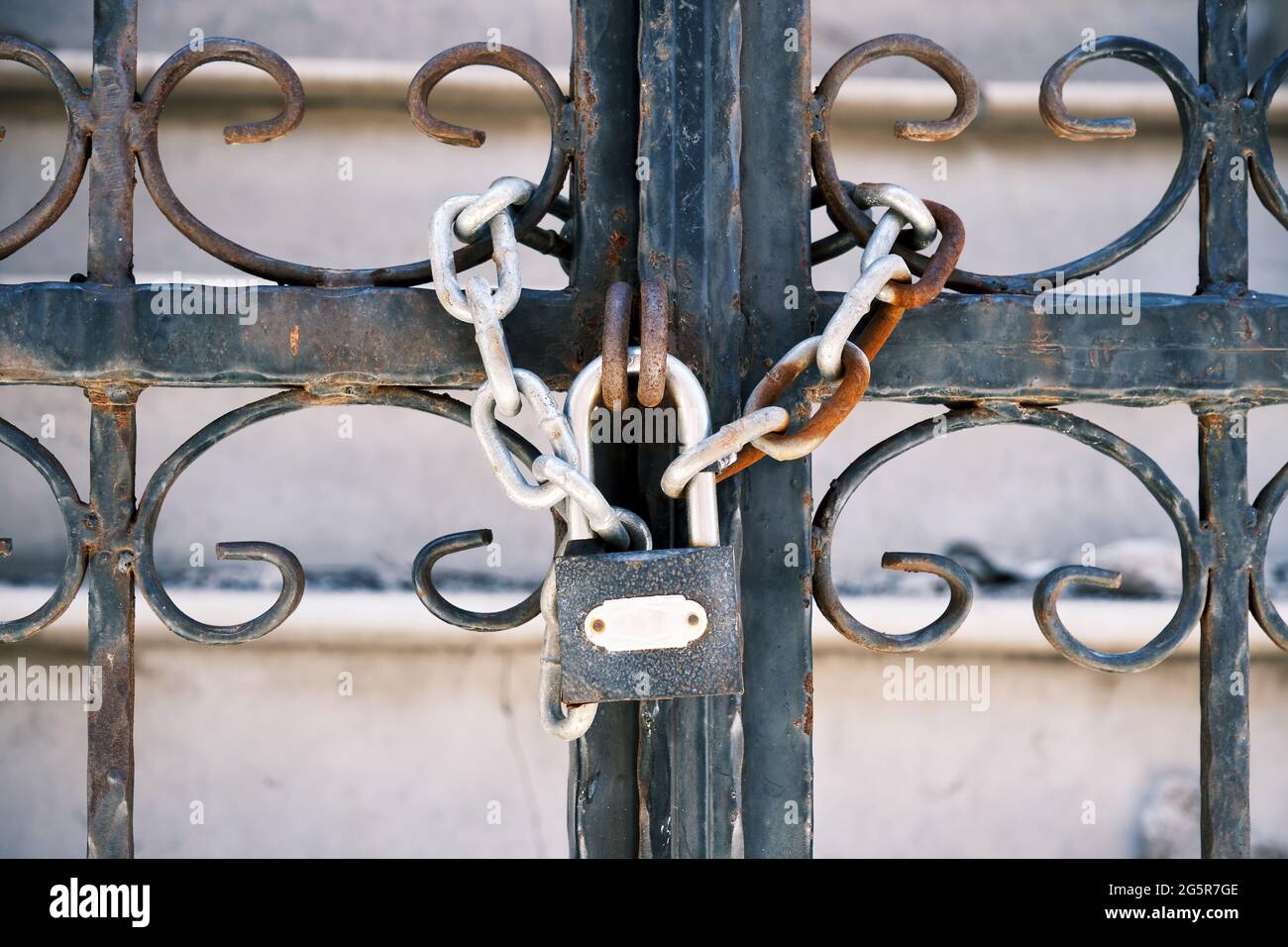 Wrought iron gate door locked with a rusty chain and padlock Stock ...