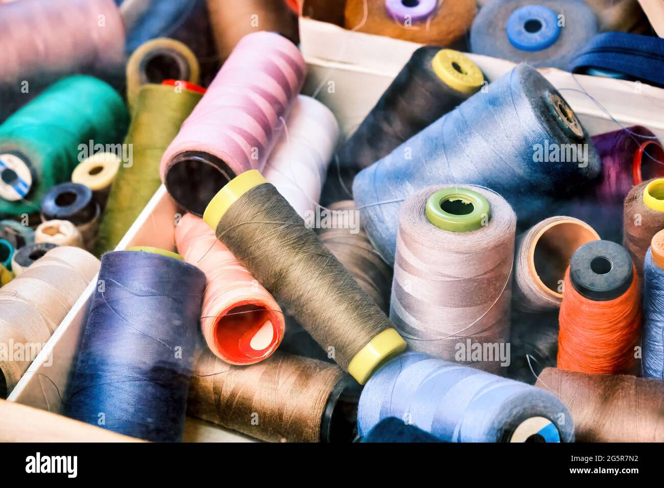 Variety of colorful sewing threads at the display window of a tailor ...