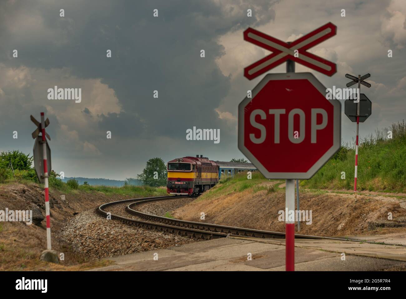 Diesel red train near Sazava river in south of Prague in summer cloudy ...